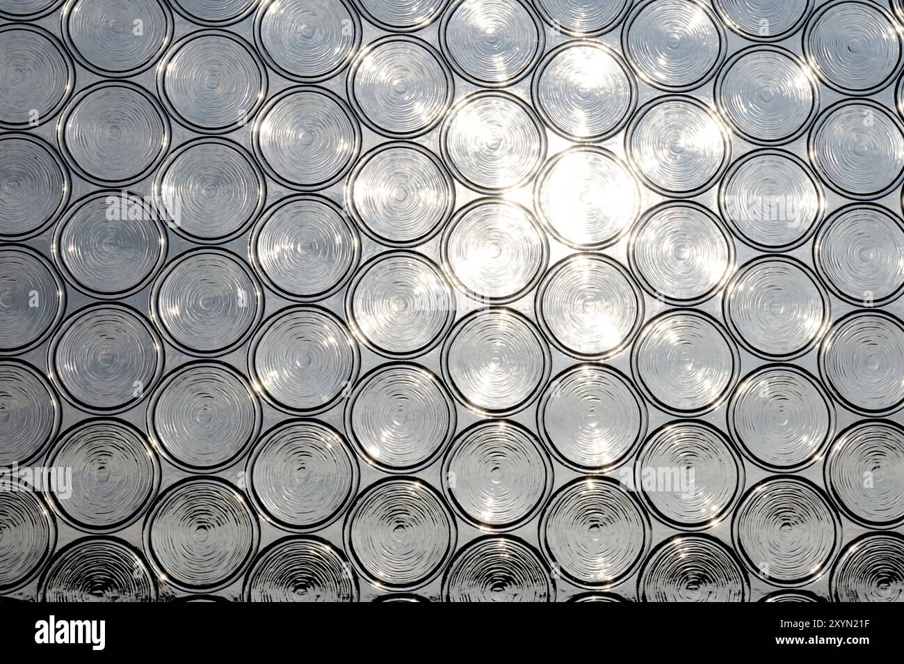 Sun seen against the light through a pane of glass with a round pattern ...