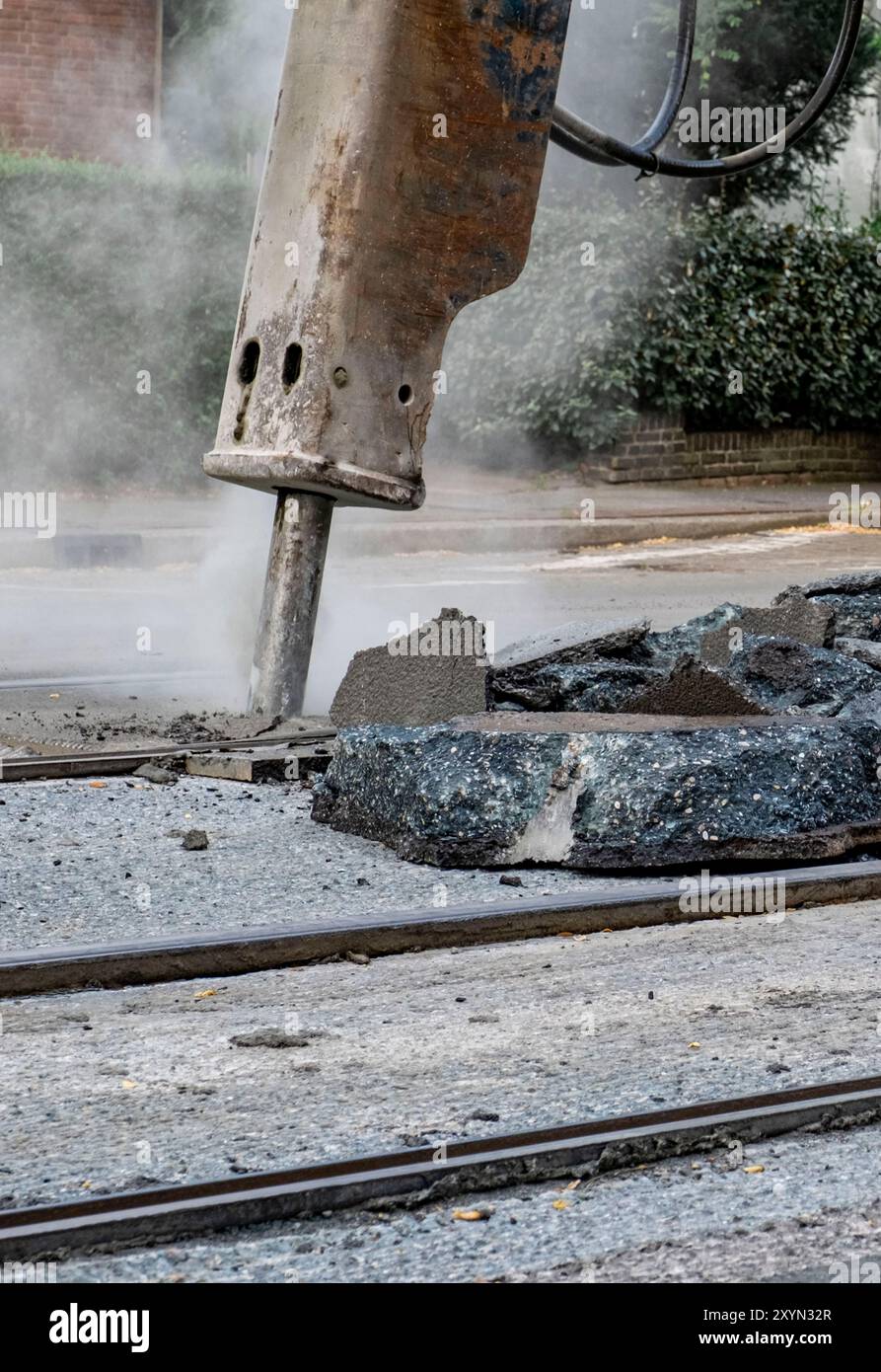 A large drilling machine removes old bad asphalt. Close-up of the drill ...