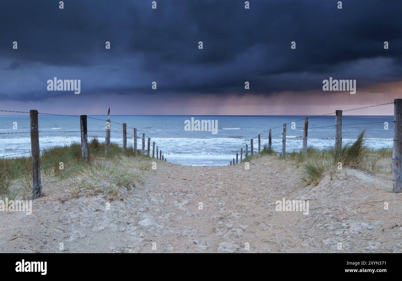 Shower coming from north sea to beach path, Holland Stock Photo - Alamy