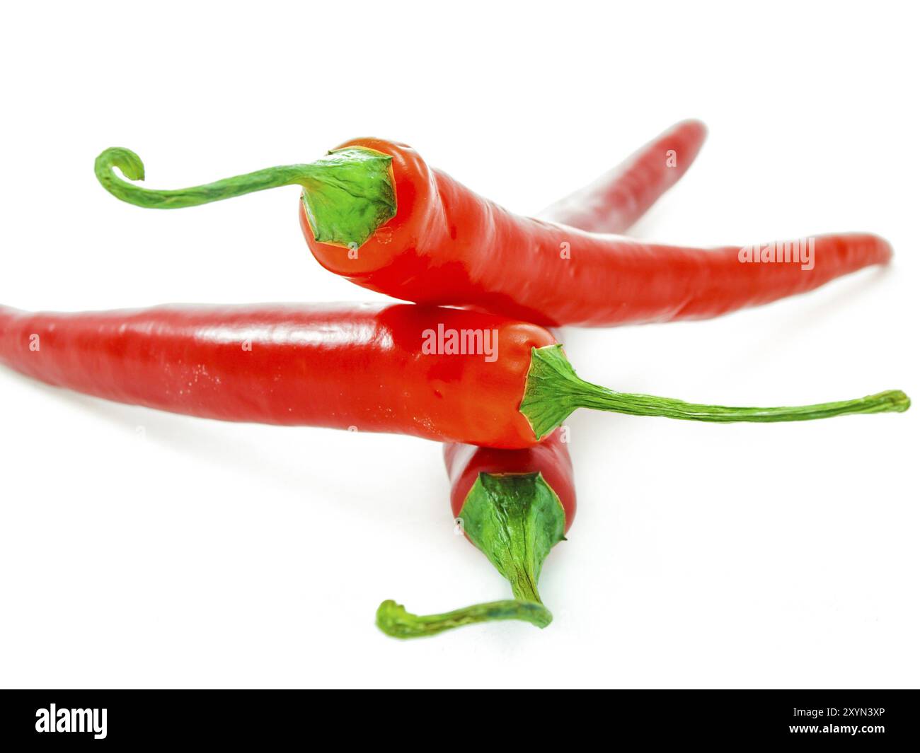 Three red chilies isolated towards white background Stock Photo - Alamy