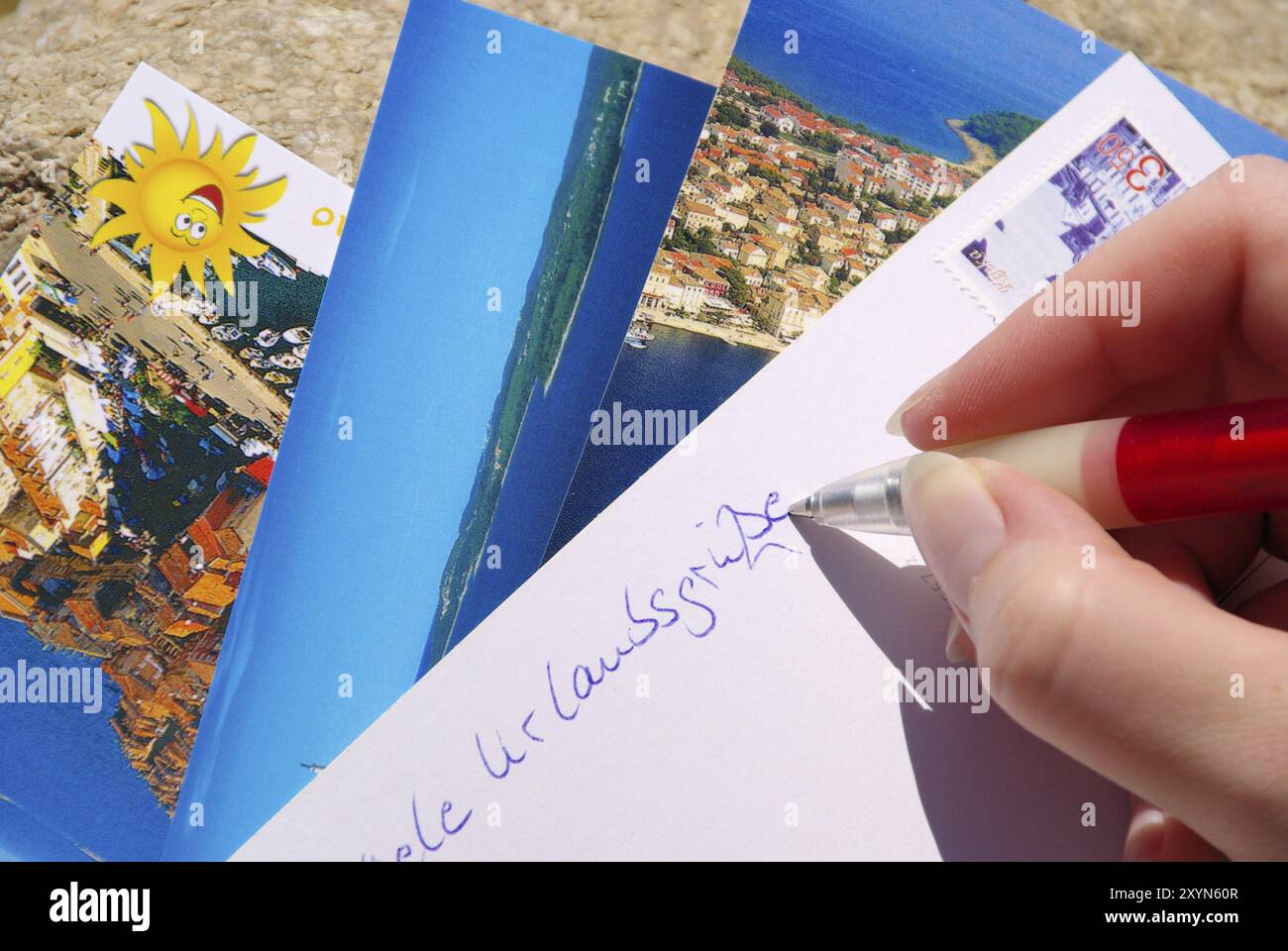 Postcard writing, writing a picture postcard Stock Photo - Alamy
