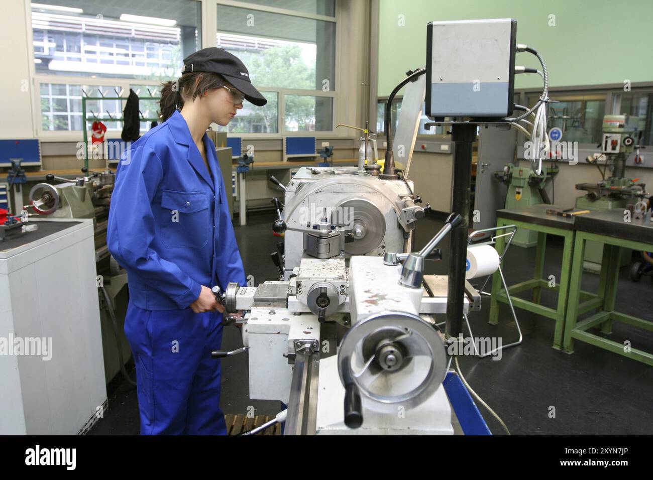 Young woman learning at a lathe, toolmaker, milling cutter, lathe ...