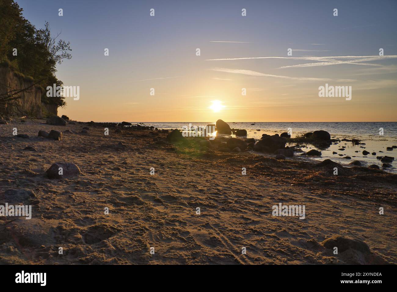 Sunset, stone beach with small and large rocks in front of the ...