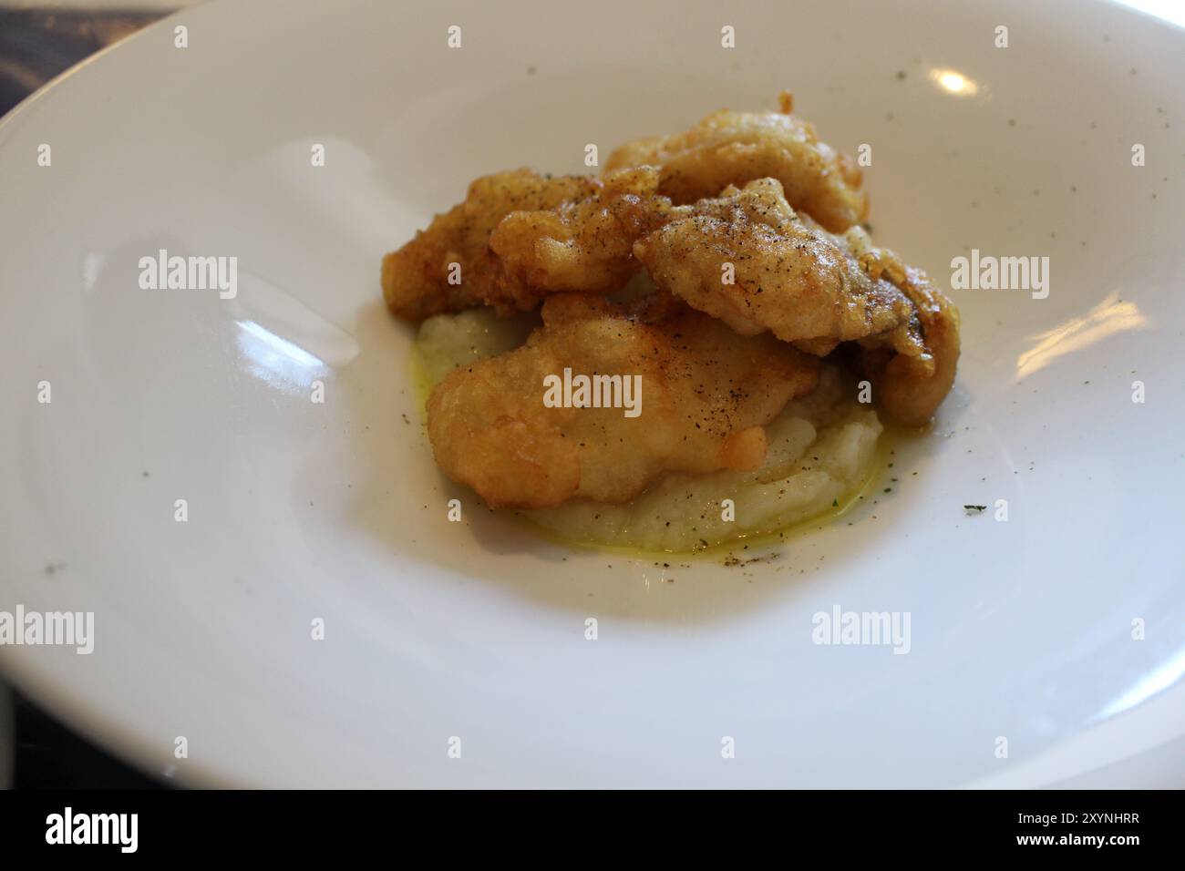Greek cuisine: bakaliaros (fried cod) with mashed potatoes Stock Photo ...