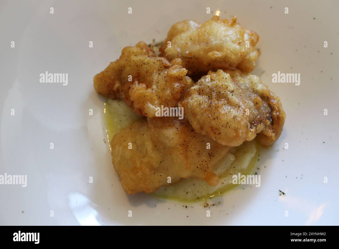 Greek cuisine: bakaliaros (fried cod) with mashed potatoes Stock Photo ...