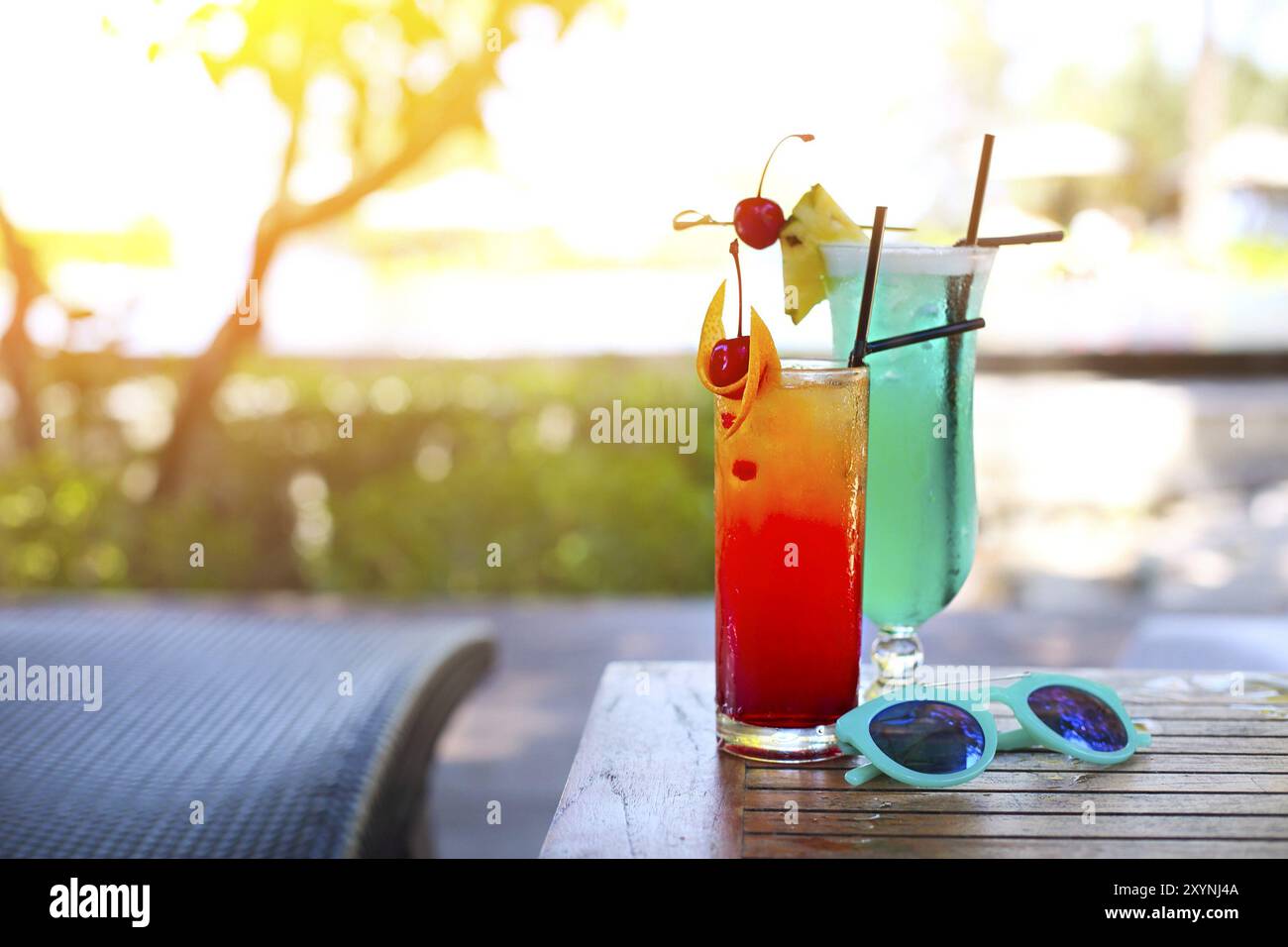 Glass with a bright blue lagoon and tequila sunrise cocktails by the ...
