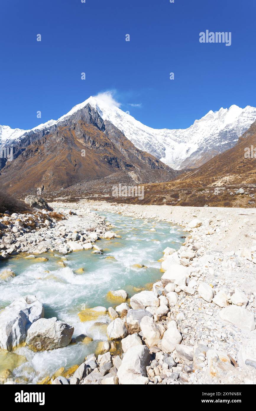 Rocky barren terrain landscape lines a fast flowing glacier water river ...