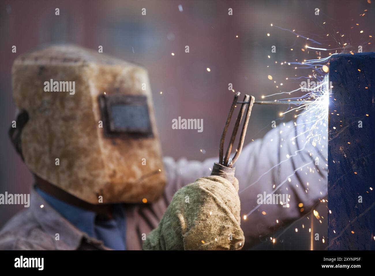 Heavy industry welder worker in protective mask hand holding arc ...