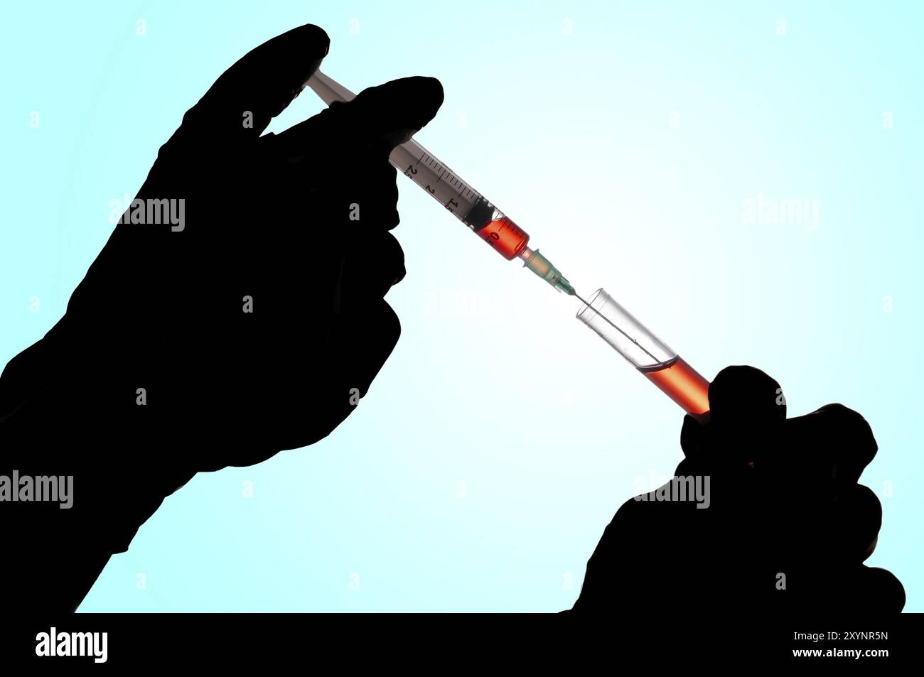 Hand holding a syringe and taking a blood sample from a tube for ...