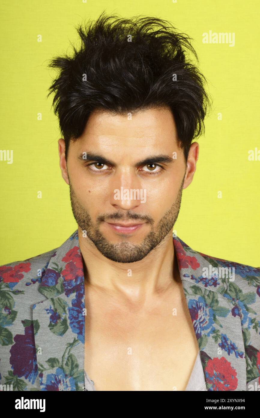 Portrait of a trendy 30 years old man with beard over a light green ...