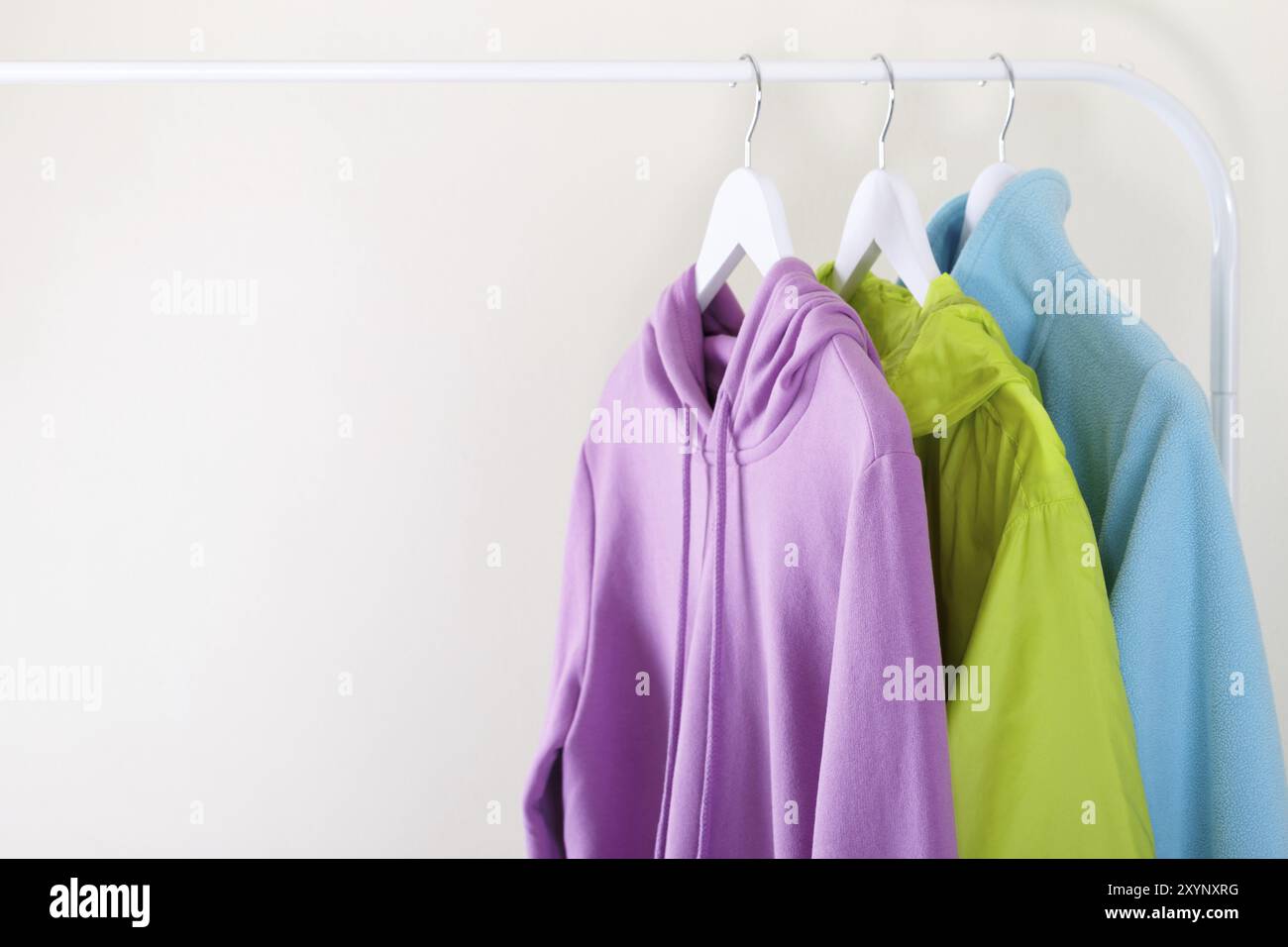 Colorful vivid sports hoodie and T-shirt hanging on a rack, trendy ...