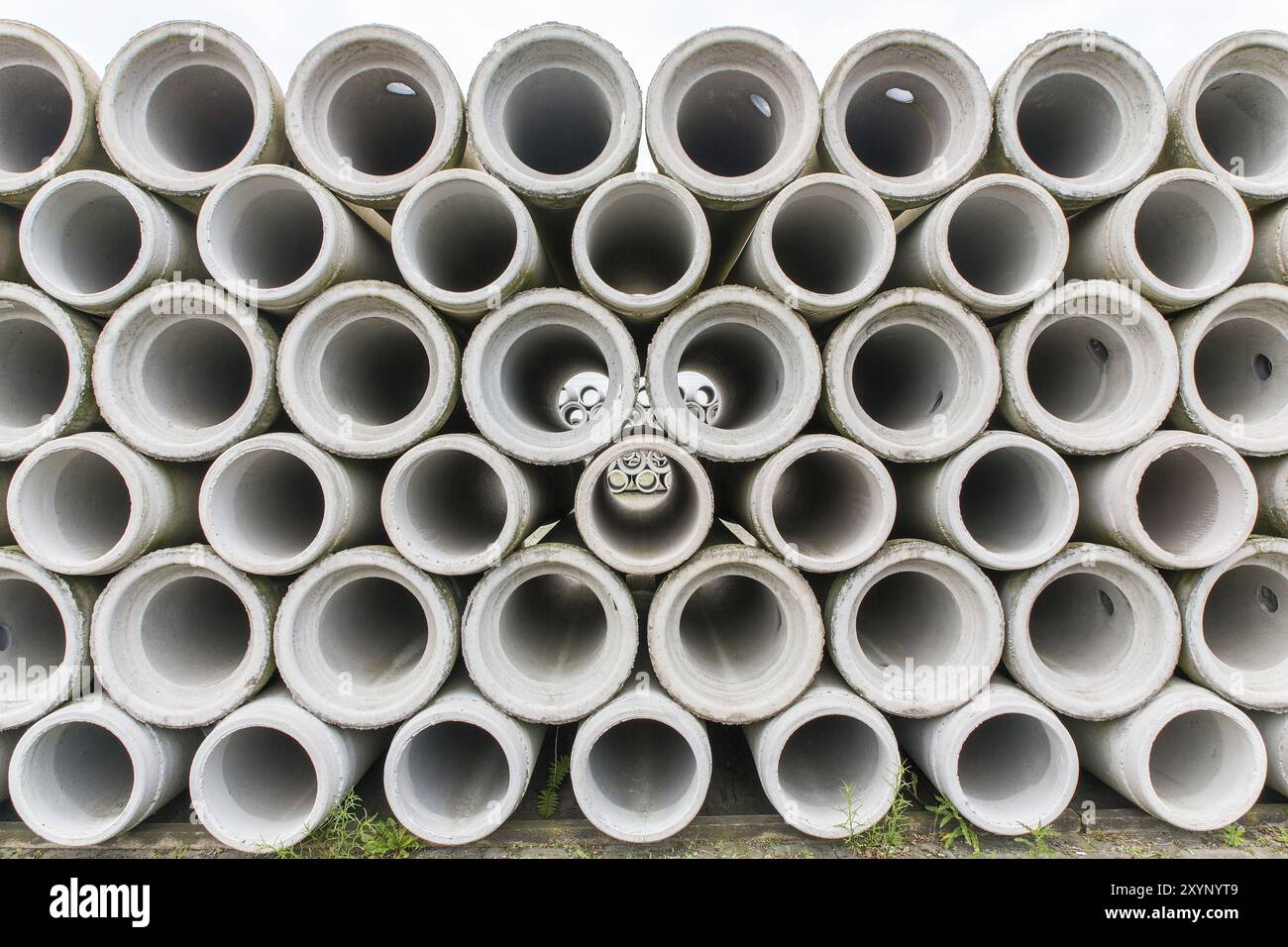 Pile of concrete sewer pipes on concrete plant grounds Stock Photo - Alamy