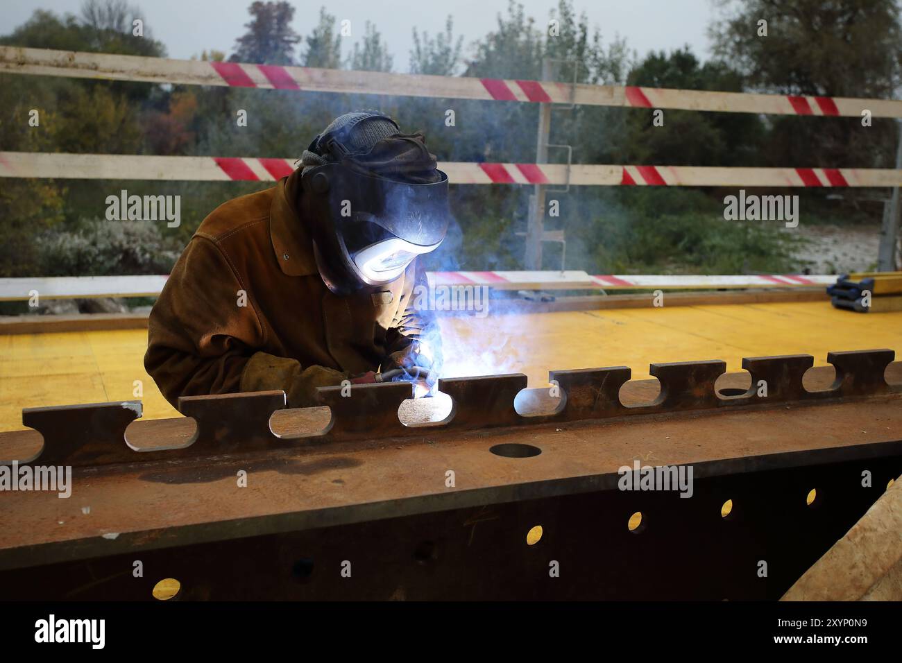 Man welding a metal part of a Saint Barbara bridge Stock Photo - Alamy