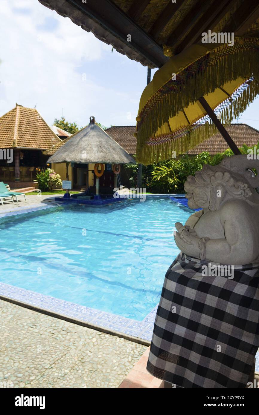 A Balinese statue and swimming pool at a resort in Kuta, Bali ...