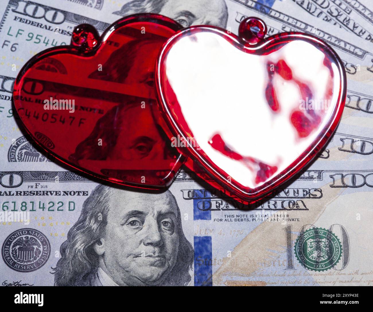 Red glass hearts on dollar bills, close up, concept Stock Photo - Alamy