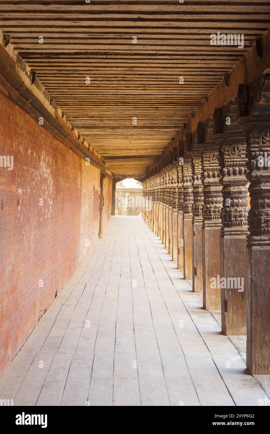 Corridor lined with repeating wooden columns lead to Durbar Square in ...