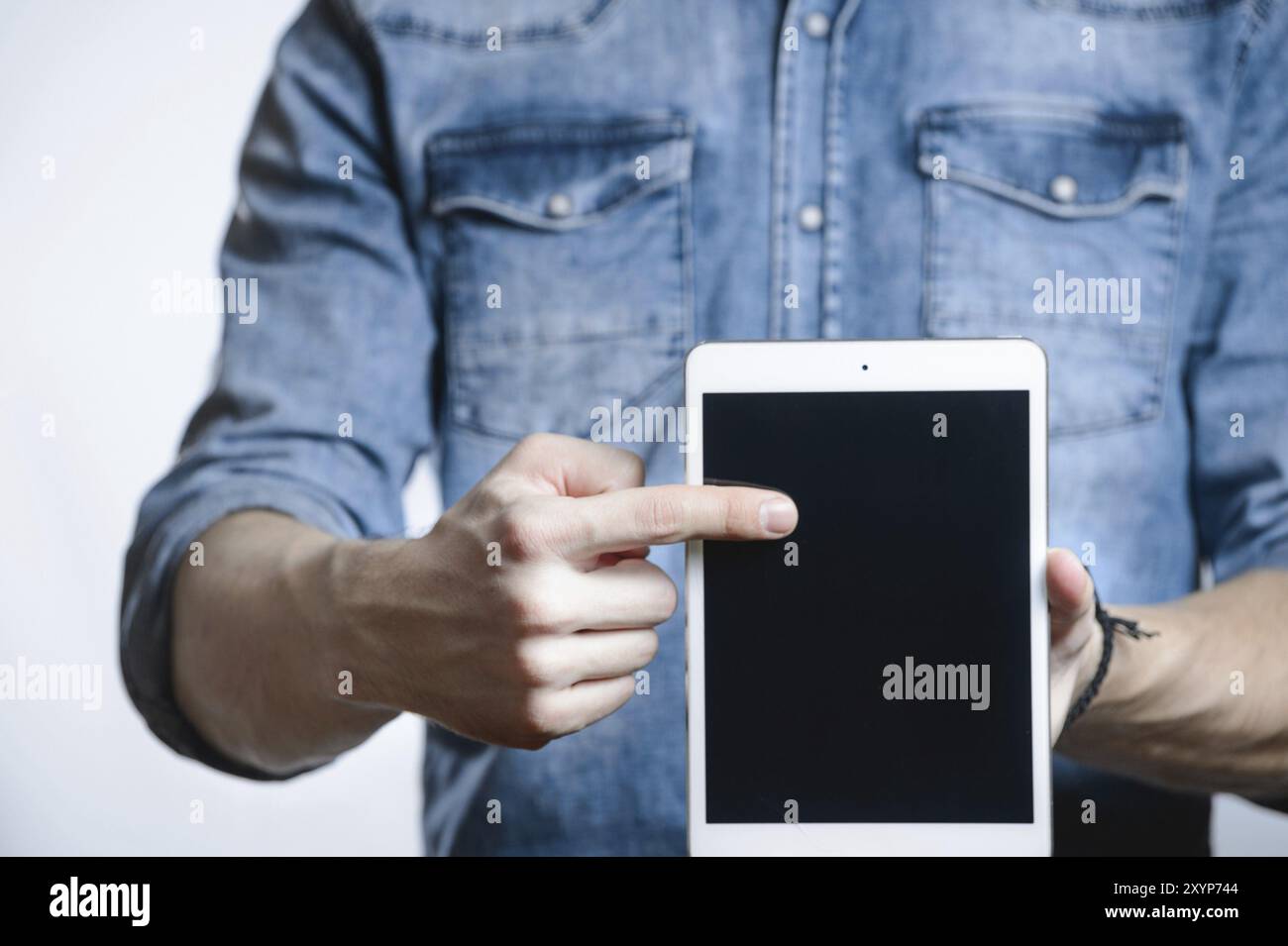 Casual man in denim shirt showing digital tablet computer screen in ...