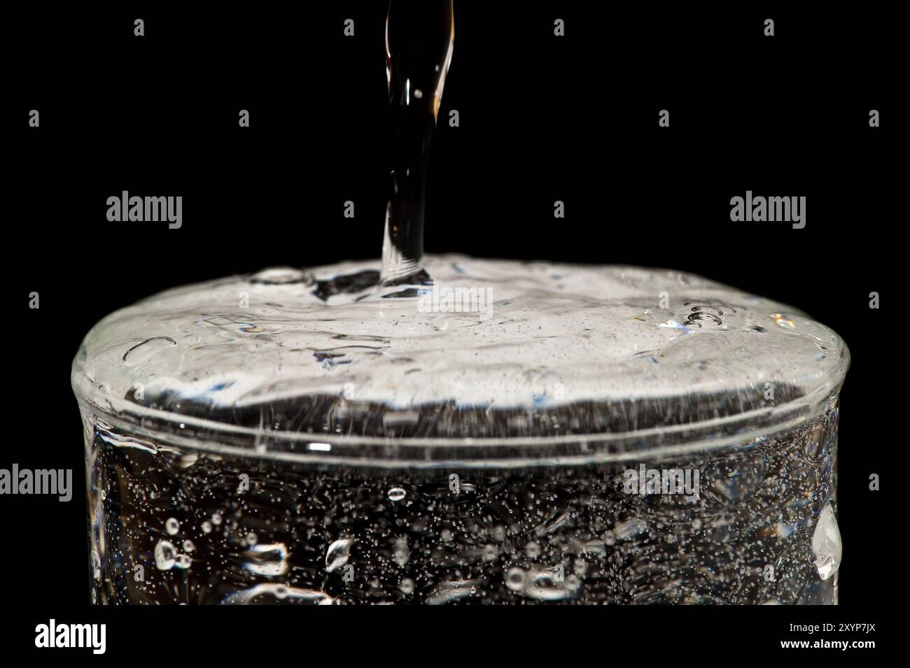 Overflowing water glass Stock Photo - Alamy