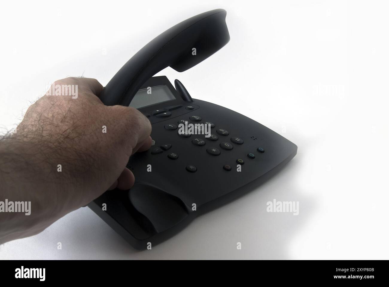 Hand with telephone receiver and telephone Stock Photo - Alamy