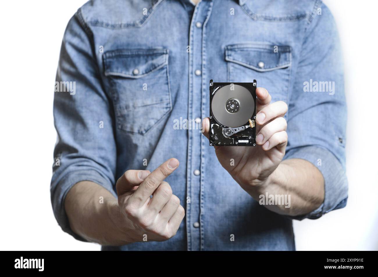 Man's hand holds a 2.5 inch hard drive. He's points to the hard disk ...