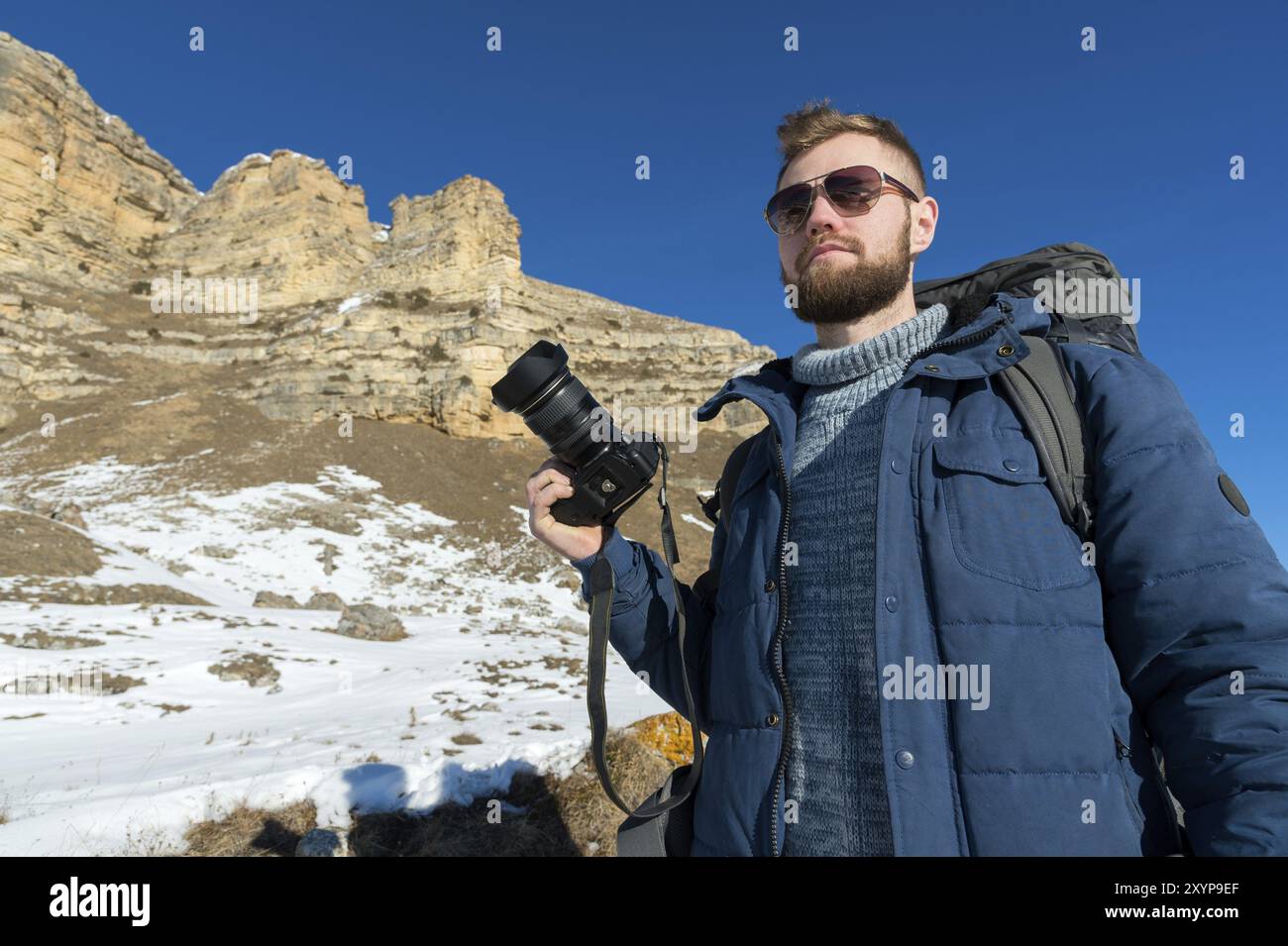 Portrait A bearded hipster photographer with a backpack and wearing ...