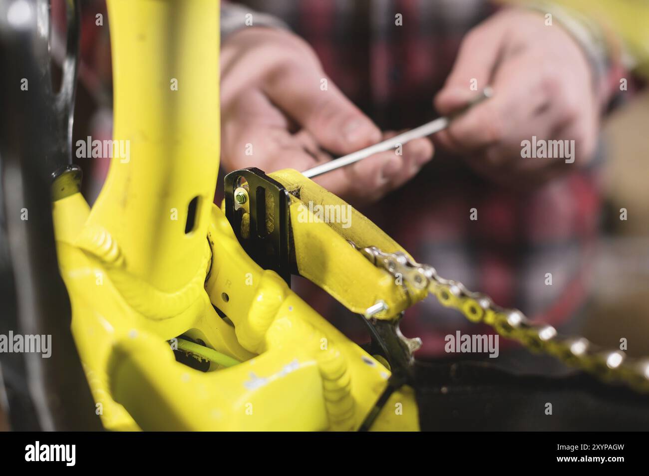 Close-up maintenance of a mountain bike. Male hands adjust the chain ...