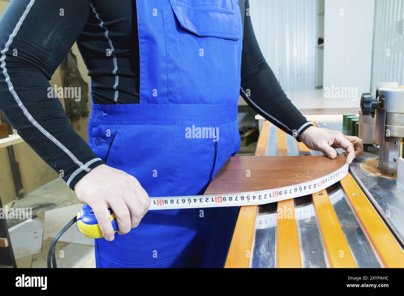 Closeup of Carpenter's hands using one meter in a cottage workshop ...