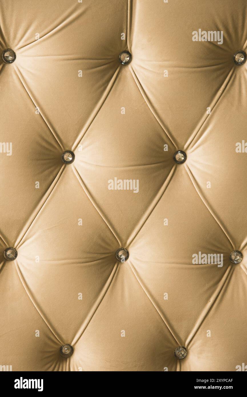 Beige soft textile background with symmetrical buttons on the corners ...