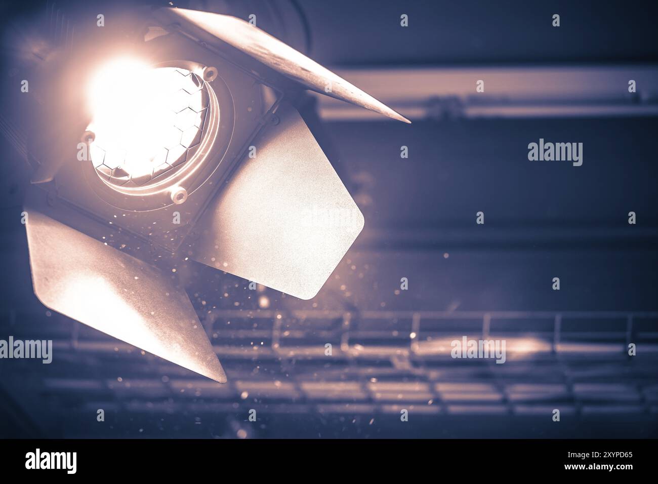 Professional orange studio spotlight hanging on the ceiling. Lighted ...