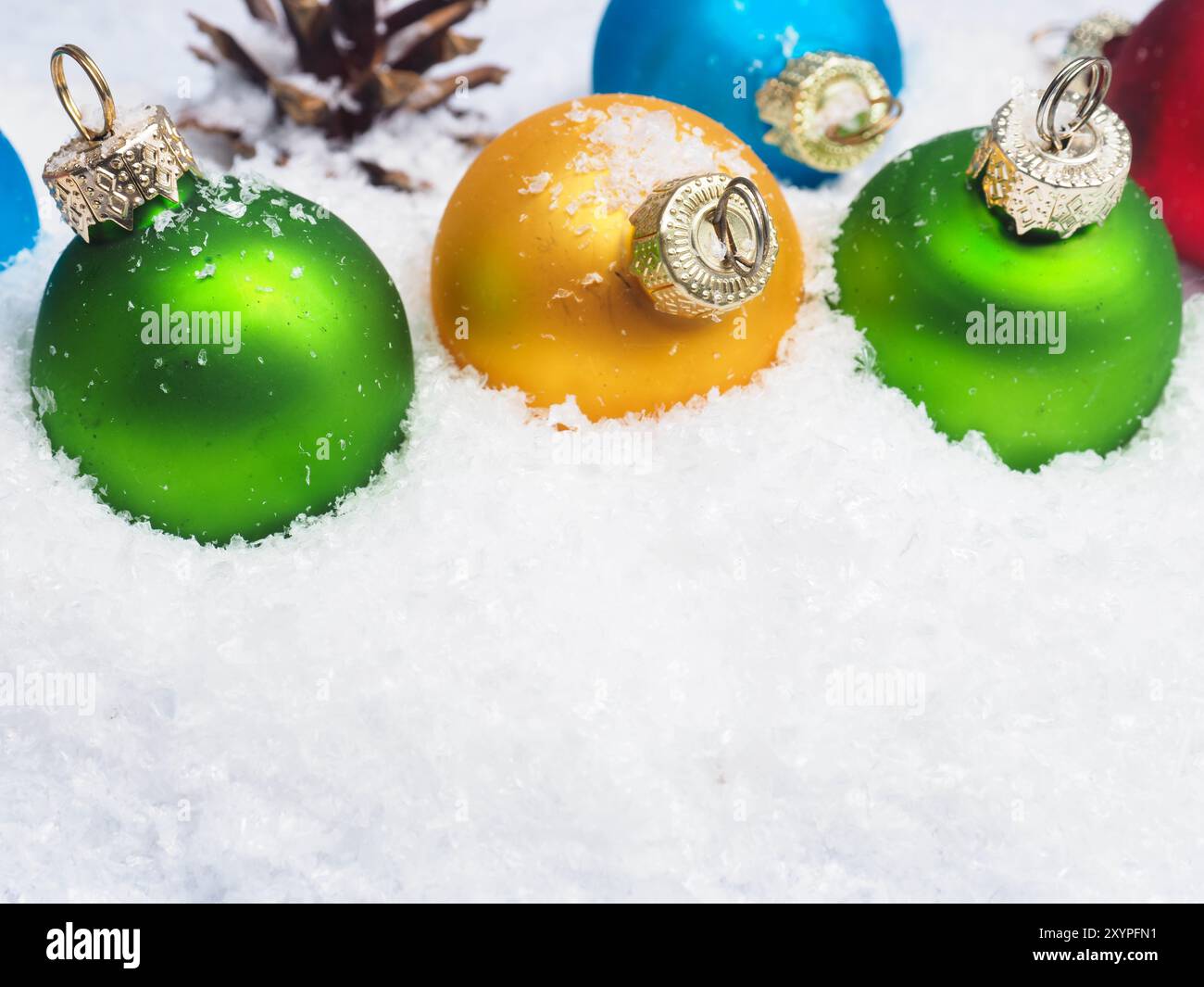 Colorful Christmas baubles in snow, seasonal background with space for ...