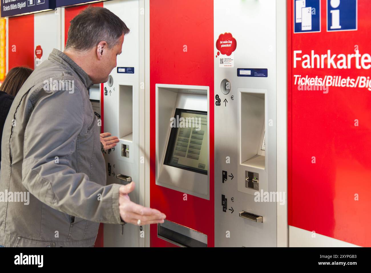 A man stands desperately in front of a ticket machine Stock Photo - Alamy