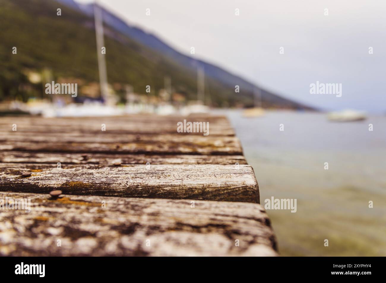 Rustic wooden dock pier, coastline in the blurry background Stock Photo ...