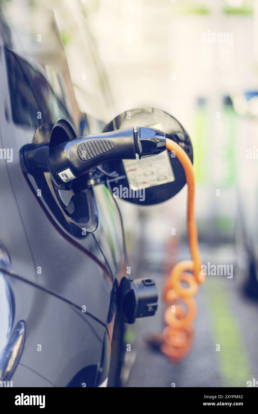 Electric car recharging with charge cable and plug leading to charge ... Electric car recharging with charge cable and plug leading to charge ...