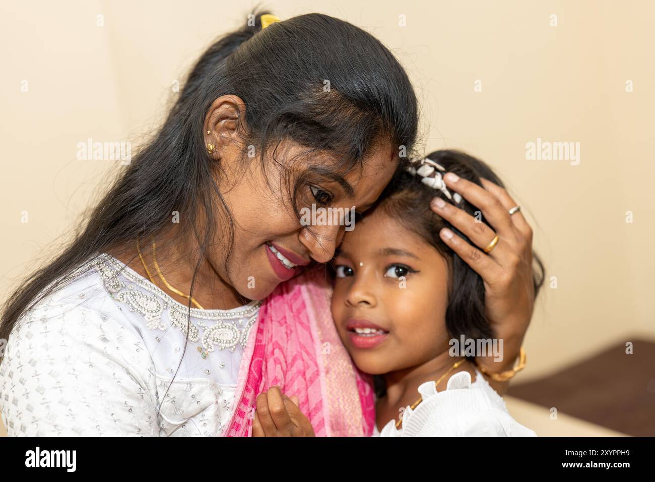 Intimate mother-daughter connection in traditional attire Stock Photo ...