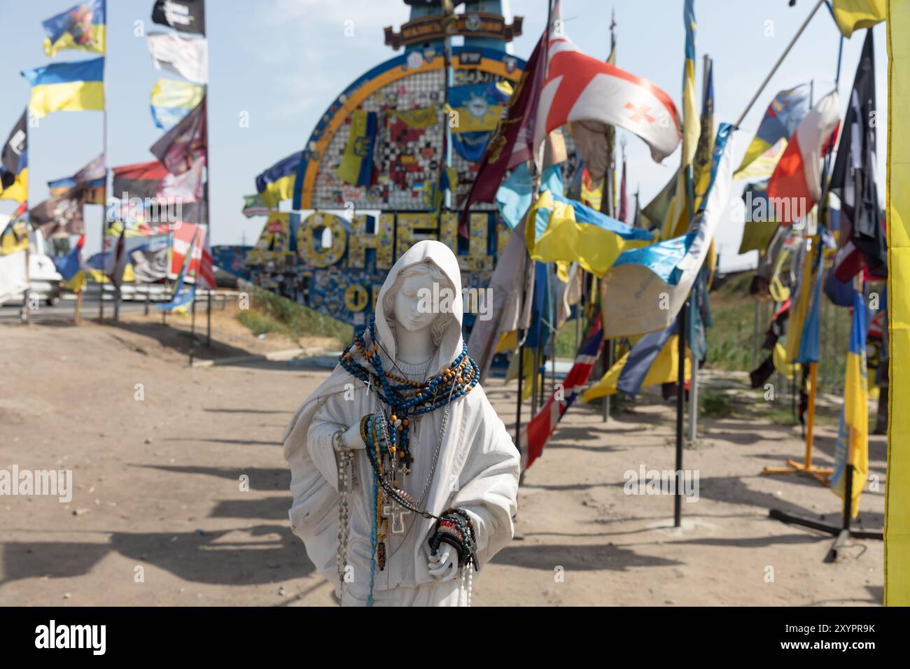 Statue of the Virgin Mary and flags of the brigades defending Donetsk ...