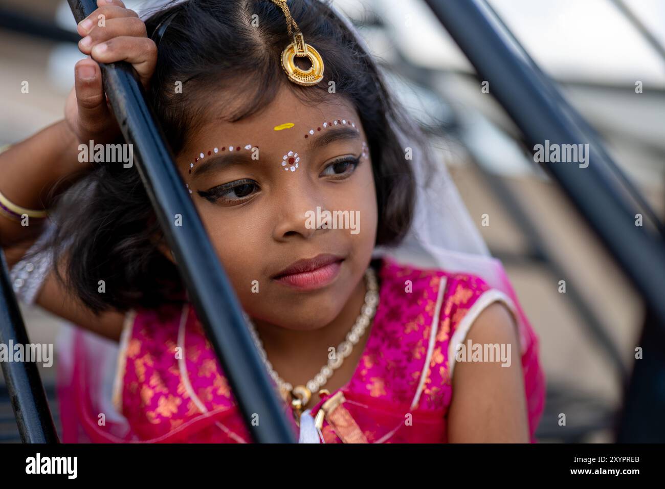 A young girl wearing vibrant traditional clothes and intricate ...