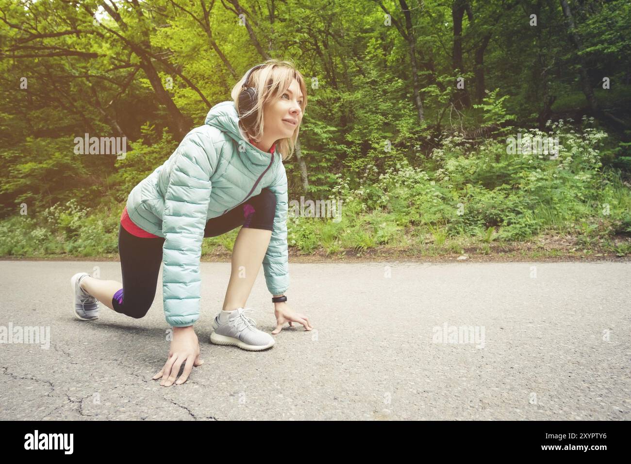Athletic woman running in countryside road. Fitness female runner in ...