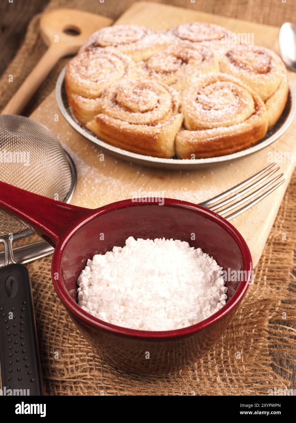 Homemade cinnamon snails with kitchen utensils on a rustic wooden ...