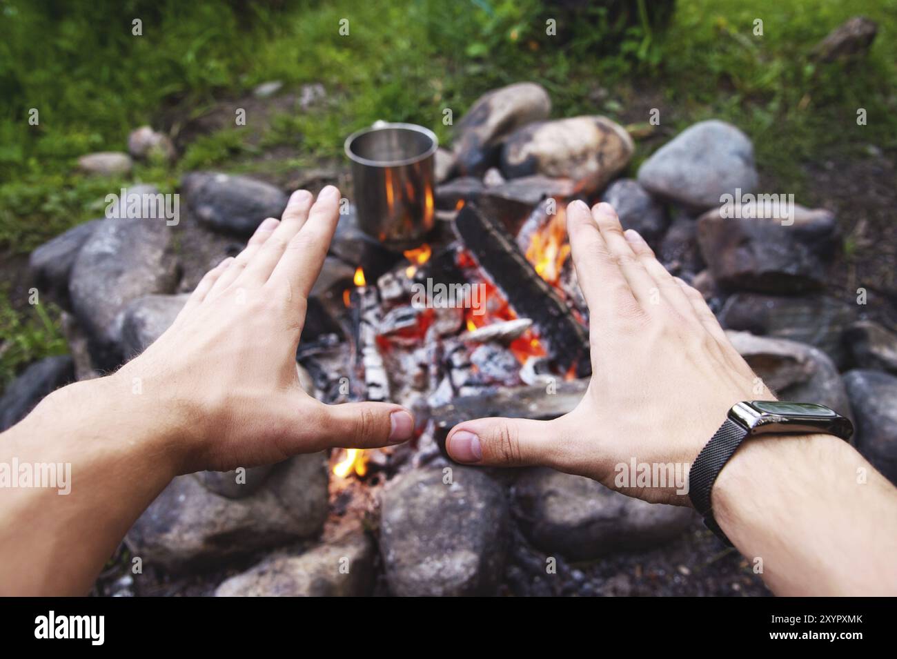 Men's hands are warming around the campfire in the forest Stock Photo ...