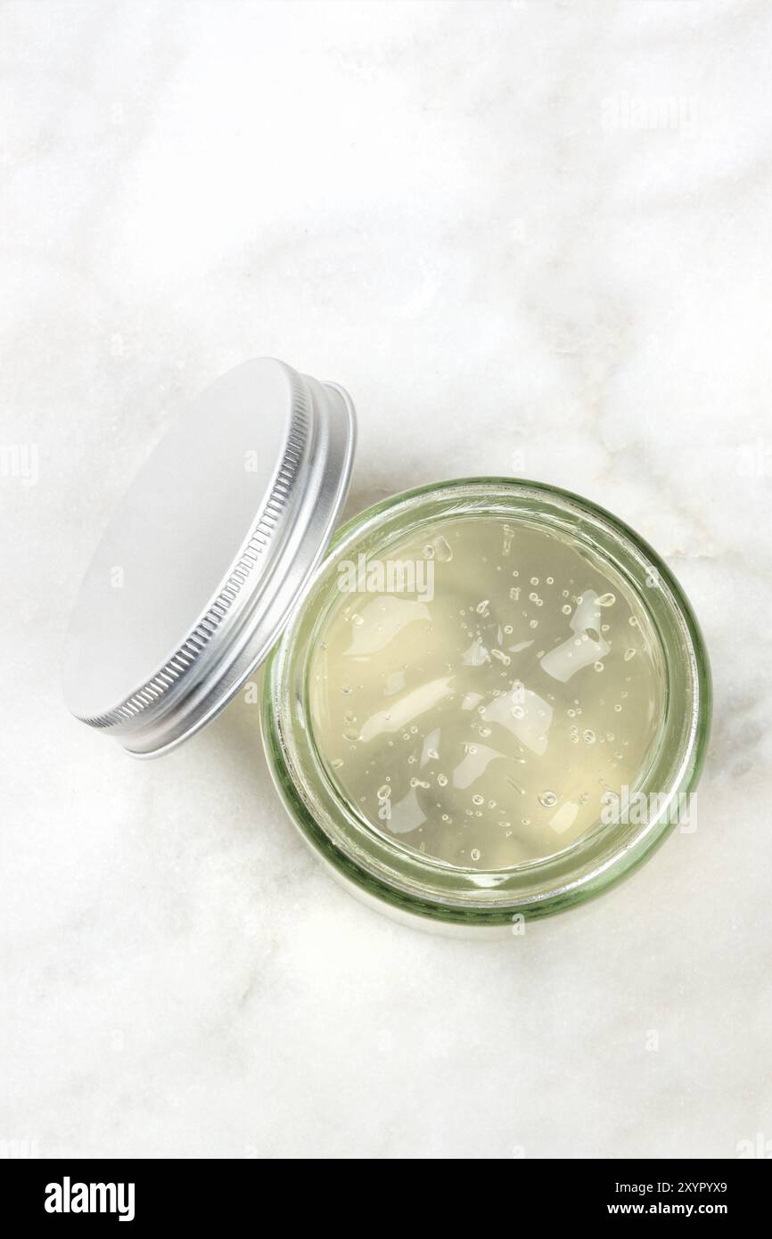 A photo of a glass jar with aloe vera gel, shot from above on a white ...