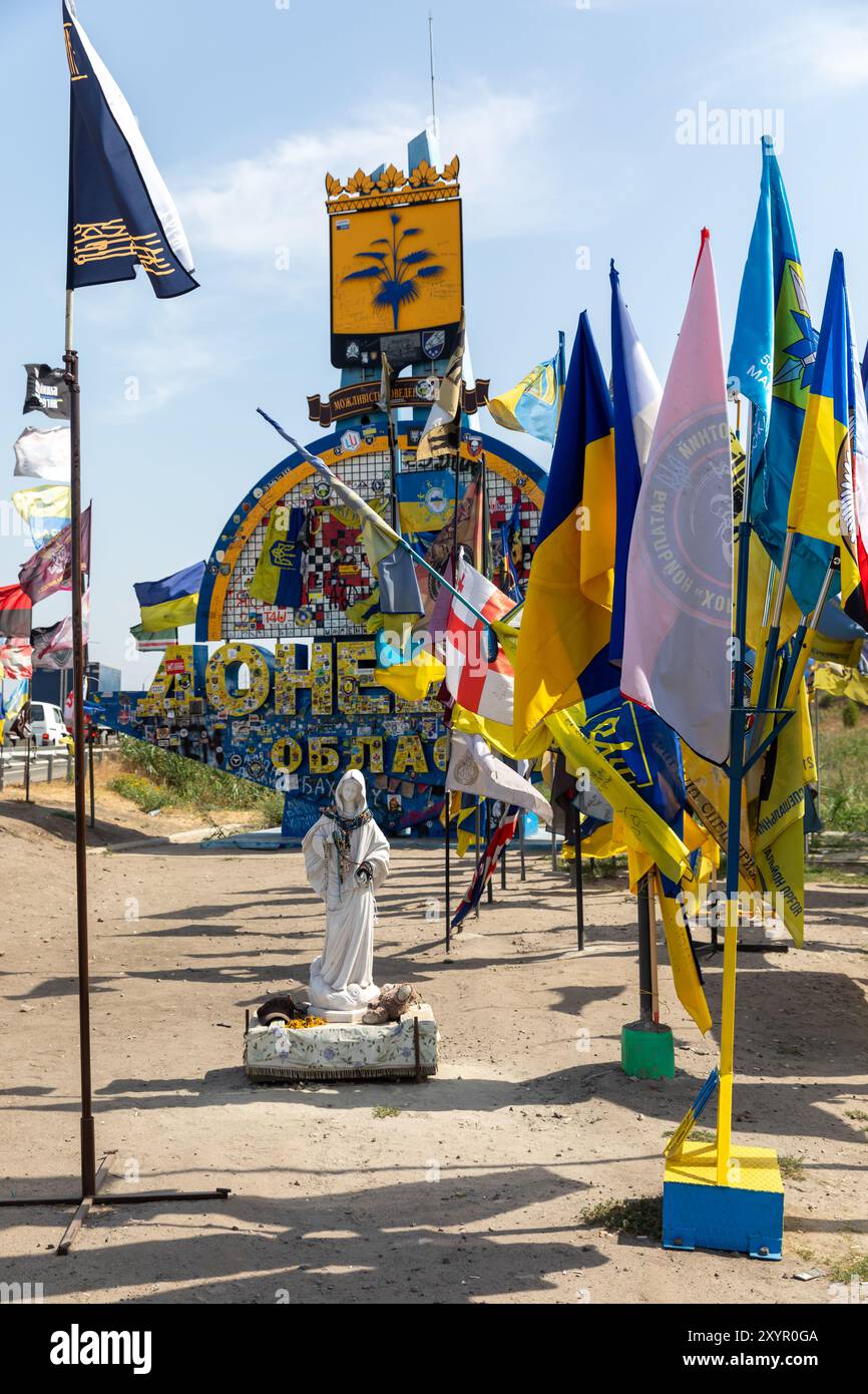 Statue of the Virgin Mary and flags of the brigades defending Donetsk ...