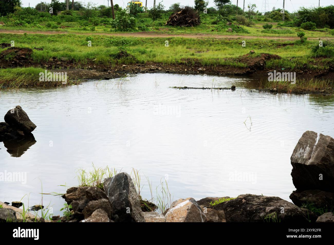 A serene view of a large body of water surrounded by rocks and lush ...