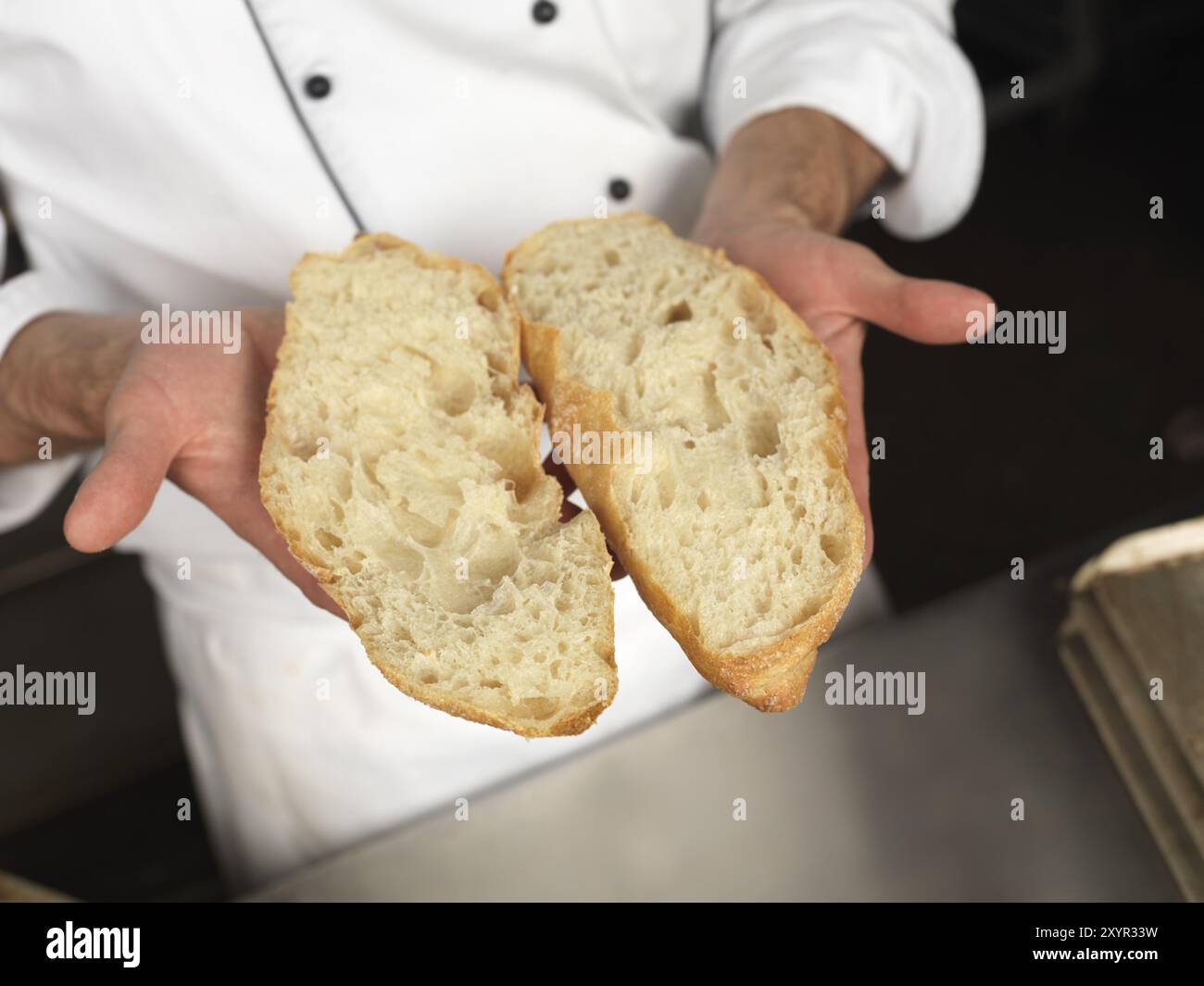 Baker showing a nice porous structure a freshly baked bread sliced in ...