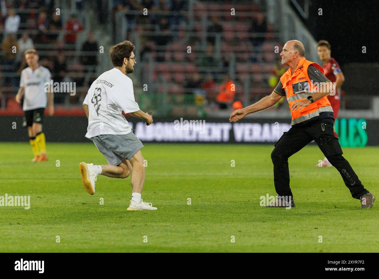 Waregem, Belgium. 30th Aug, 2024. A hooligan runs on the football pitch ...