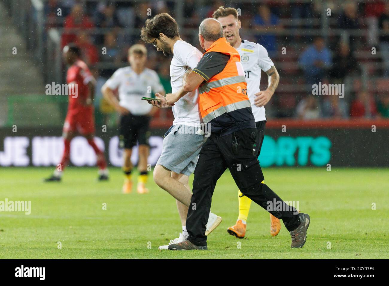 Waregem, Belgium. 30th Aug, 2024. A hooligan runs on the football pitch ...