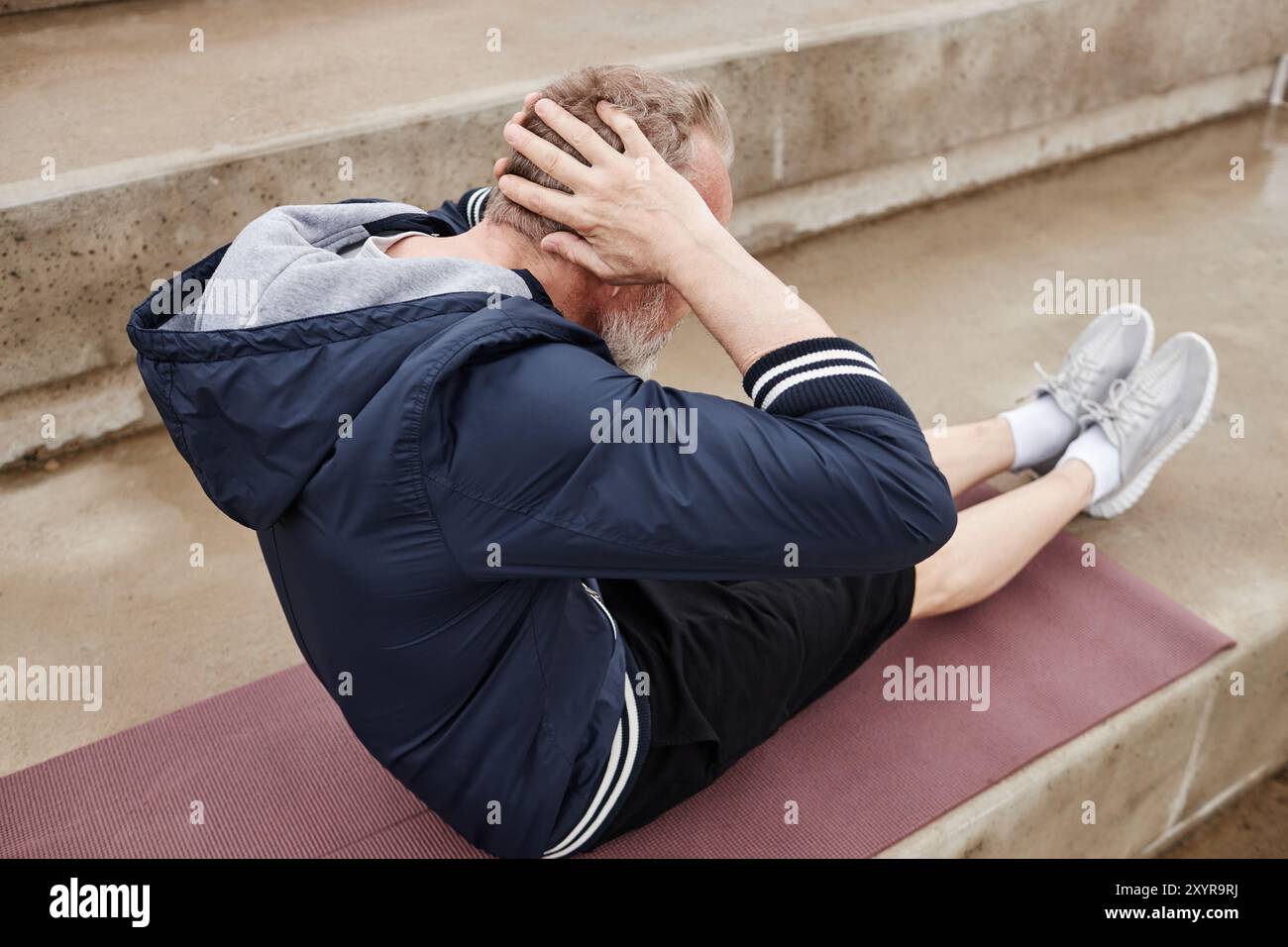 Side view of senior man doing crunches on yoga mat strengthening ab ...