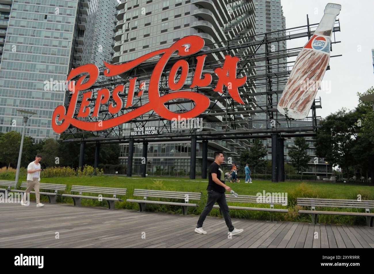 People walk in front of the Pepsi Cola sign at Gantry Plaza State Park ...