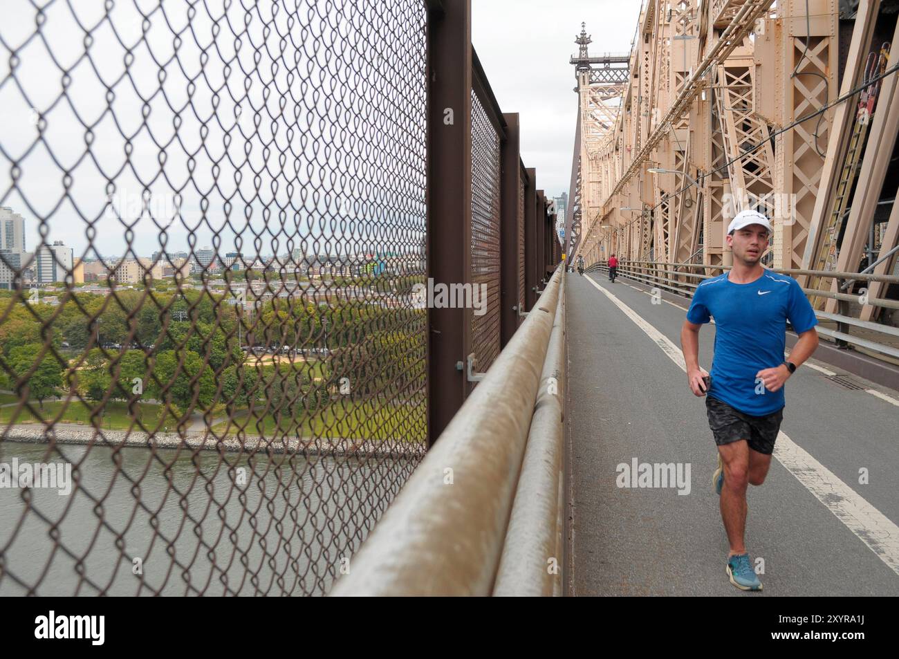 A man jogs across the Queensboro Bridge in New York City Stock Photo ...