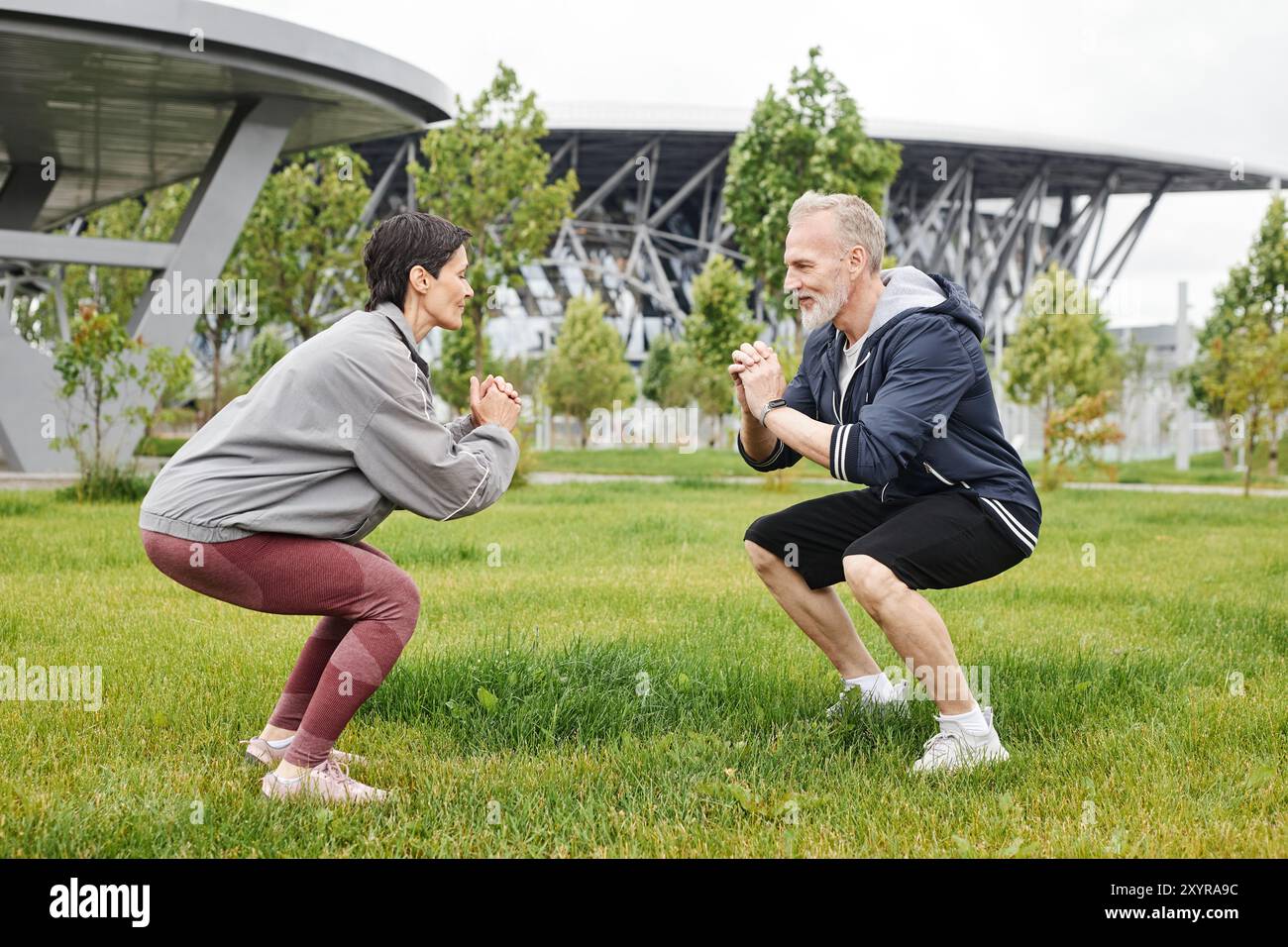 Side view of fit senior man and woman in static squat hold position ...