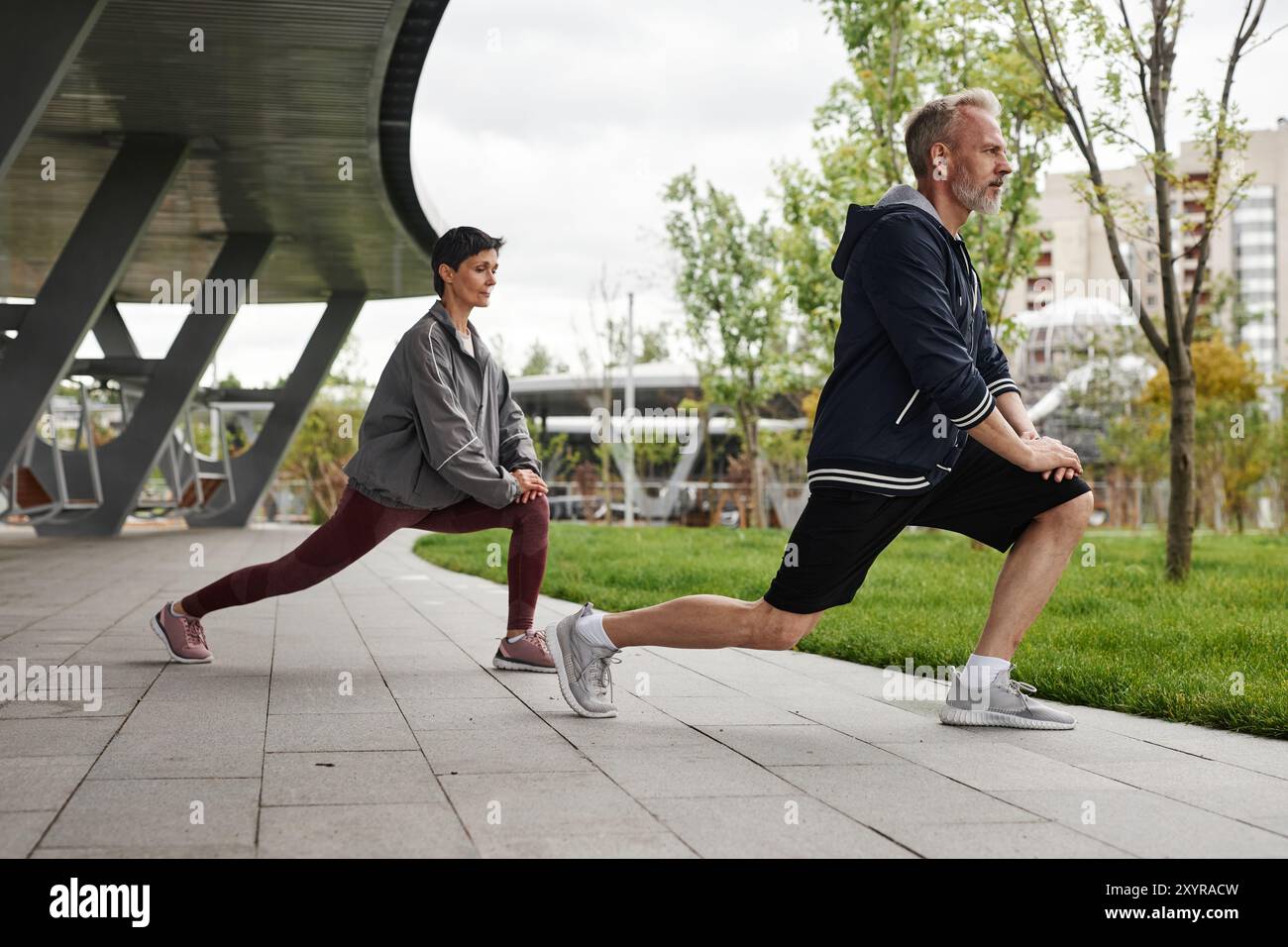 Side view of fit senior man and woman in static lunge pose ...